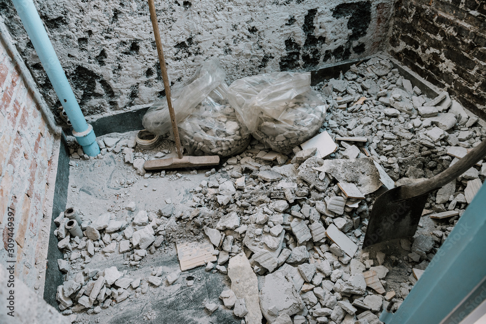 Tearing down and destruction of a bathroom, concrete and broken bricks ...