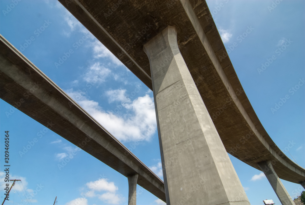 Tall concrete columns supporting freeway traffic ramps and connectors ...