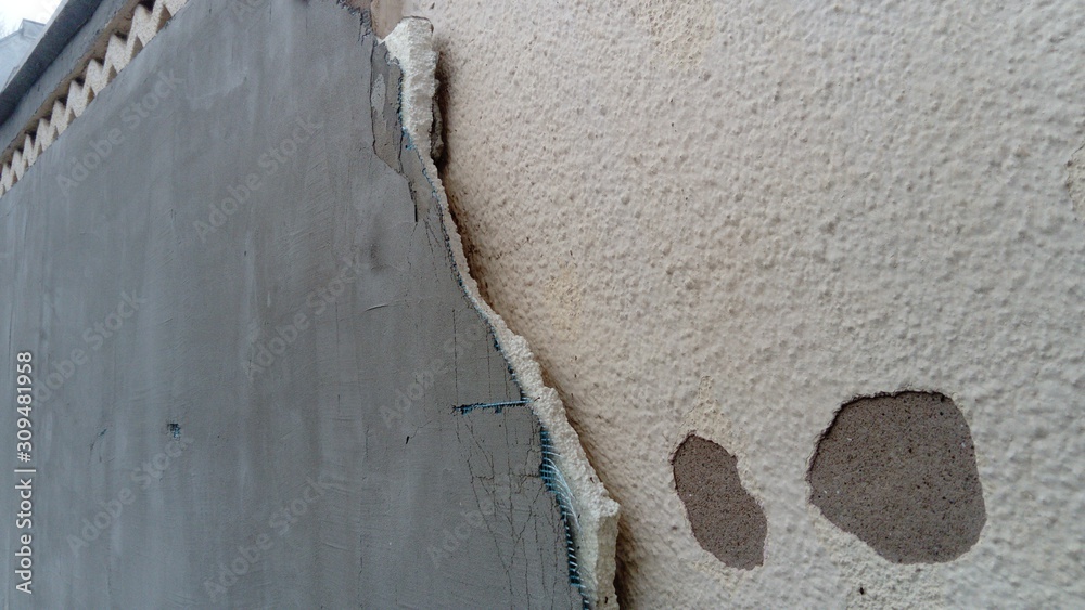 Crack on the wall of the house. Old plaster falls off the surface ...