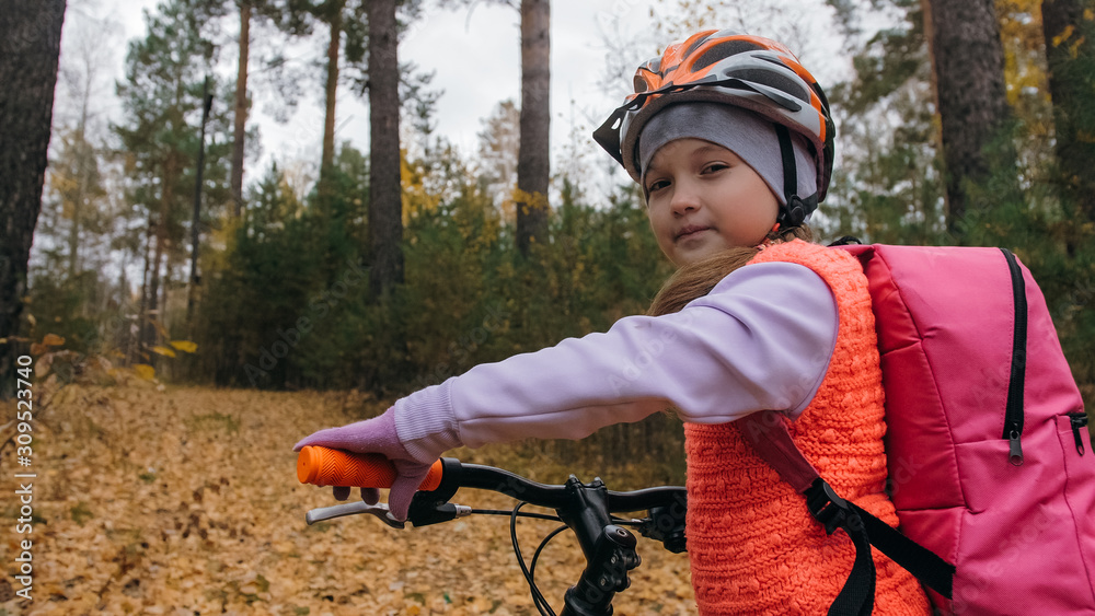 One caucasian children walk with bike in autumn park. Little girl ...