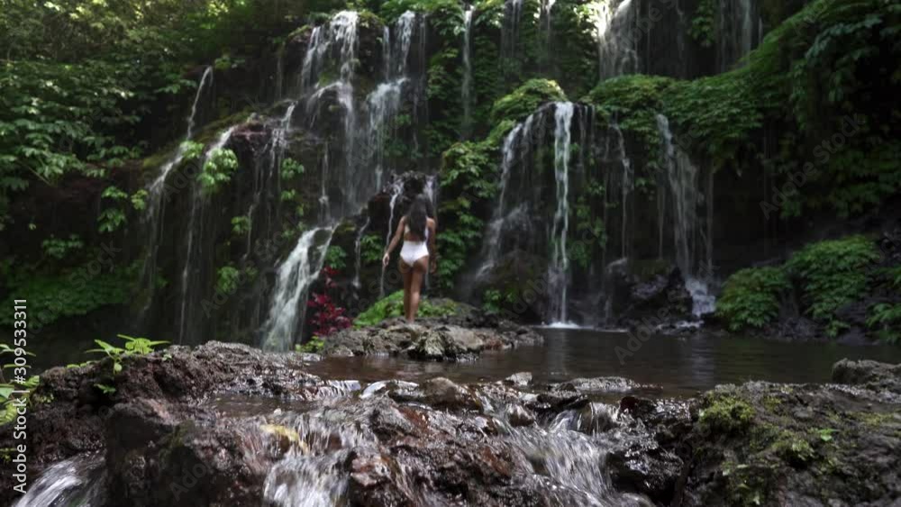 Woman enjoying near hidden in jungle cascade waterfall in Bali. Slim ...