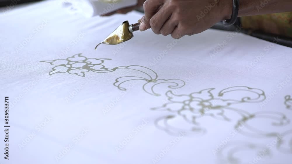Close-up video of a process of making written batik. Batik is a ...