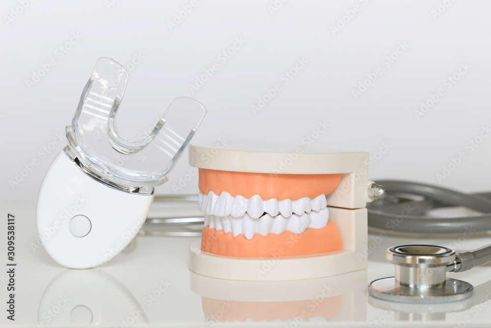 Tooth model with LED light for whitening teeth on white background ...