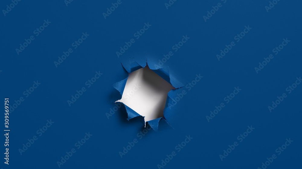 Breakthrough paper hole with blue textured background. Mockup for ...