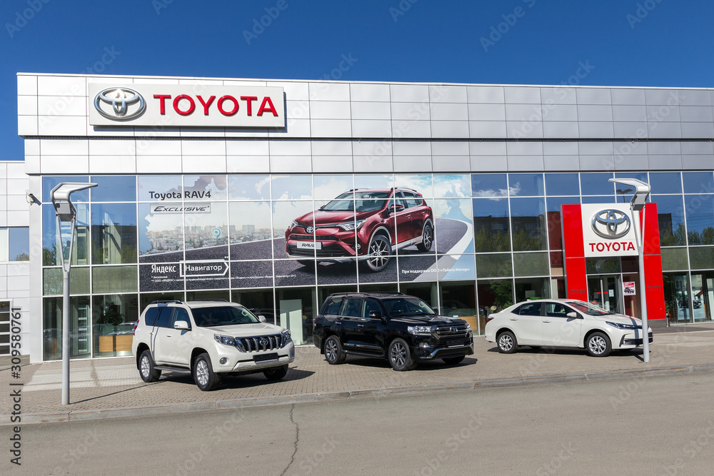 Toyota dealership with a modern facade and cars on display in front of ...