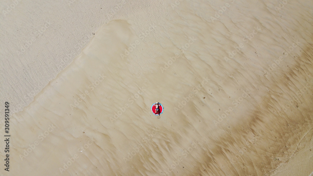 Aerial view of Young woman lying on the beach blanket, sunbather on ...