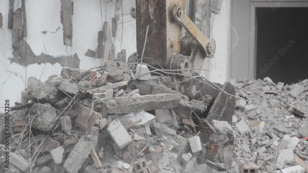 Remains of a damaged building after an earthquake in Thumanë. Excavator ...