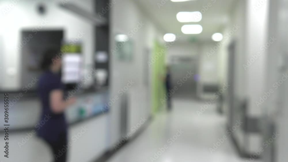 Doctors, nurses, patients and other employees walk around the hospital ...