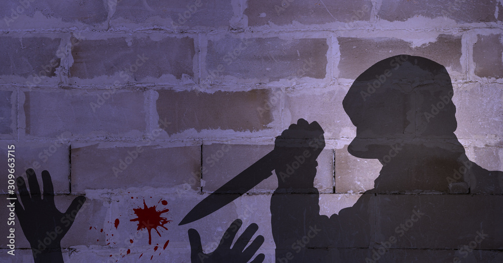 shadows of a killer with knife and hands of a murdered person reflected ...