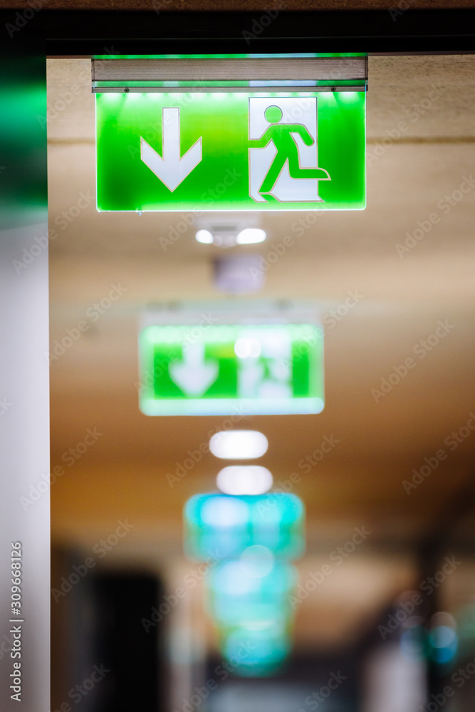 Green Exit Sign pointing to the nearest emergency exit in a modern ...