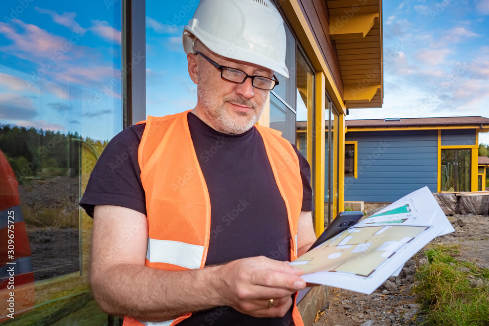 Man with drawings of the house. Work on the construction site. Adult ...
