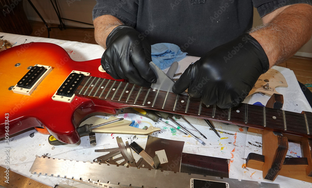 Guitar repair - checking the fret height and level with a rocker tool ...