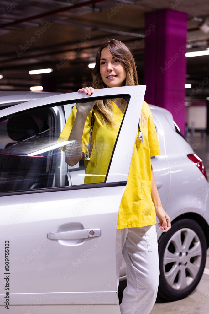 Attractive young girl riding in her car to go to work at the hospital ...