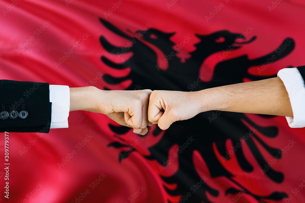 Albania agreement concept. Man and woman fist bumping on national flag ...