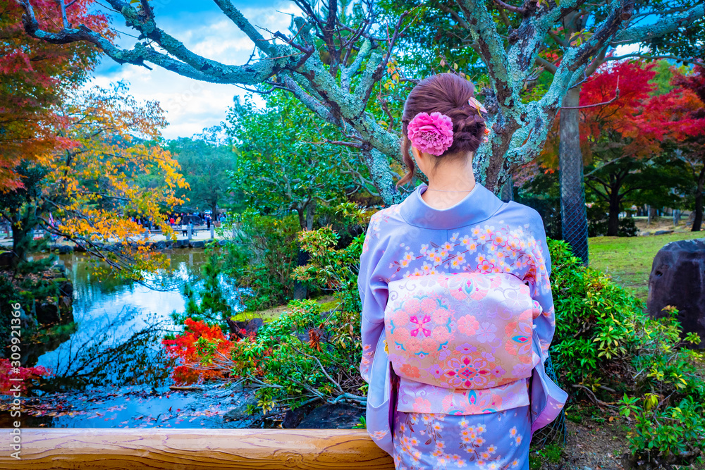 Japan. Nara Park. A girl in a kimono stands on the bridge. Japanese woman in national clothes ...