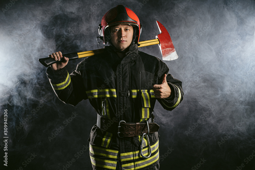 strong confident fireman saving and protecting from fire, wearing ...