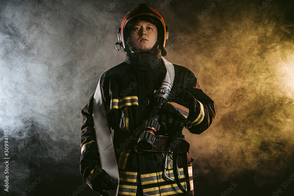 Foto de portrait of confident handsome fireman in helmet and uniform ...