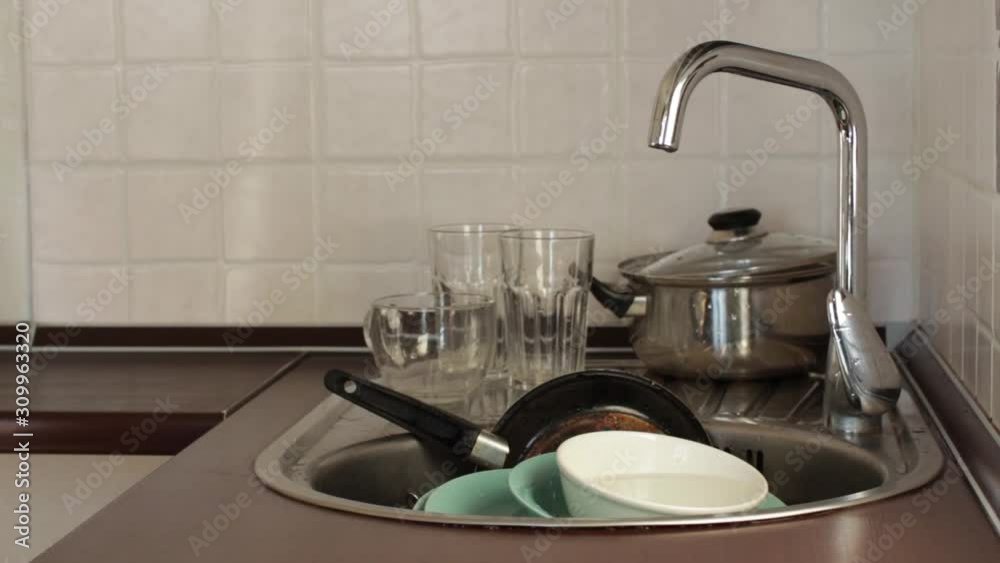 leaking faucet in a kitchen with sink full of ditrty dishes Stock Video ...