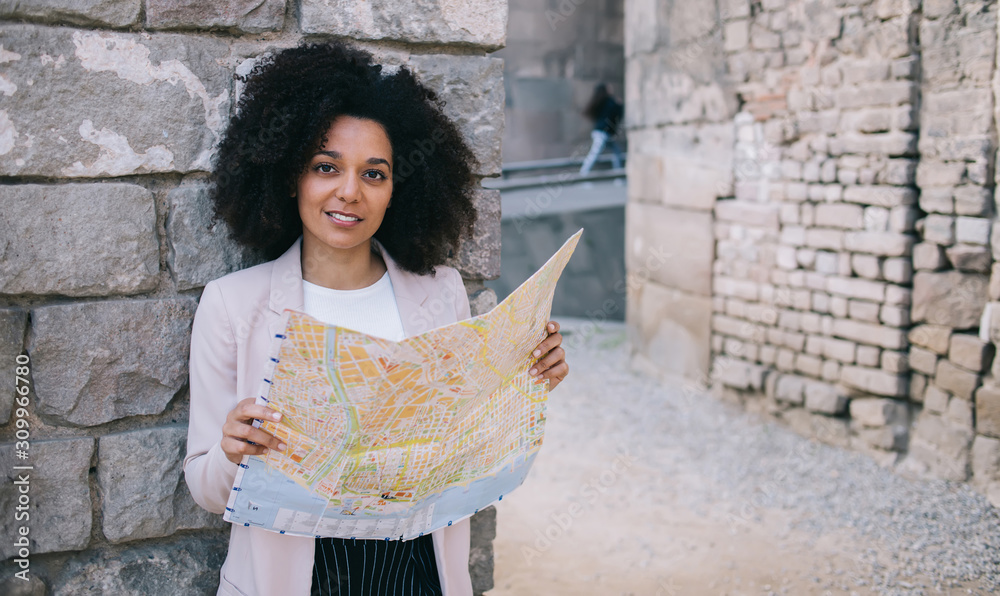 Dark skinned lady with map near historic building Stock Photo | Adobe Stock