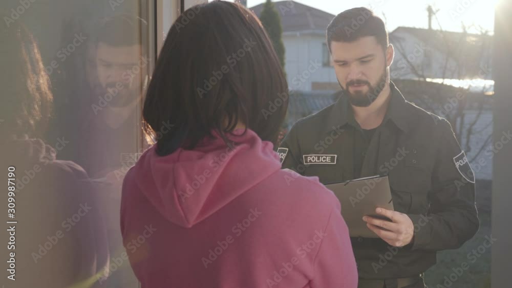 Back view of brunette Caucasian woman talking with police officer ...