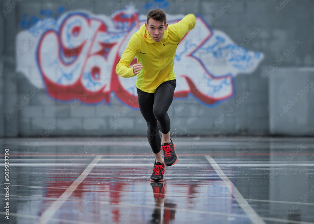 sprinter running frontally towards the camera, wet ground Stock Photo ...