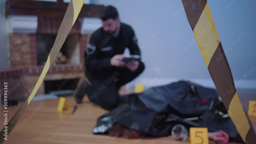 Blurred Caucasian police officer sitting next to the murder victim and ...