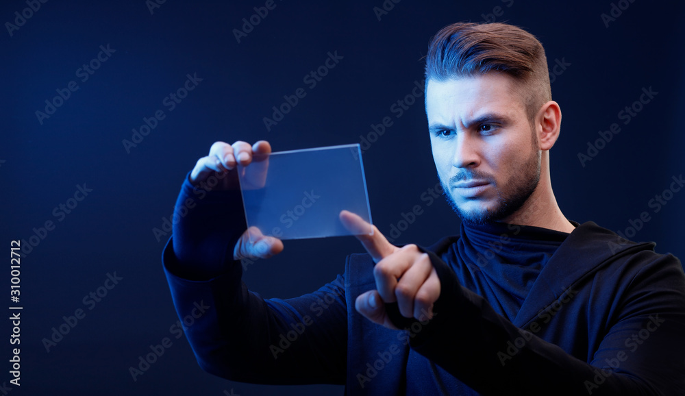 Young man with beard and trendy hairstyle in hoody uses futuristic ...