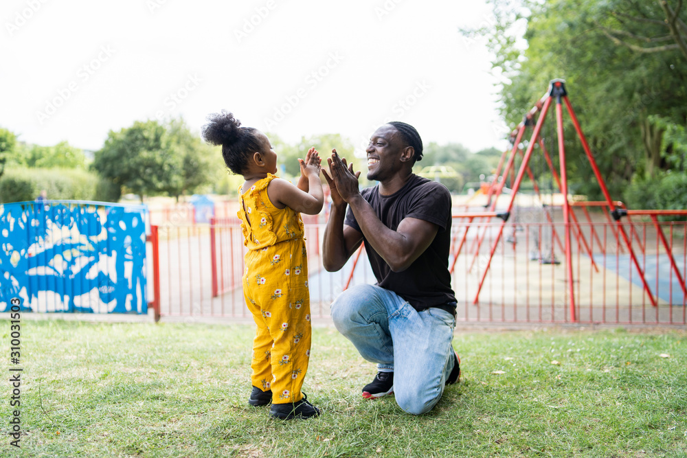 Happy father and daughter playing a clapping game in a park Stock Photo ...