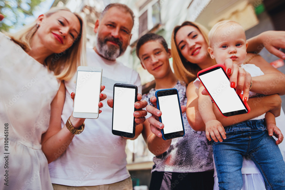 Hands of family members holding mobile smart phones with white screen ...