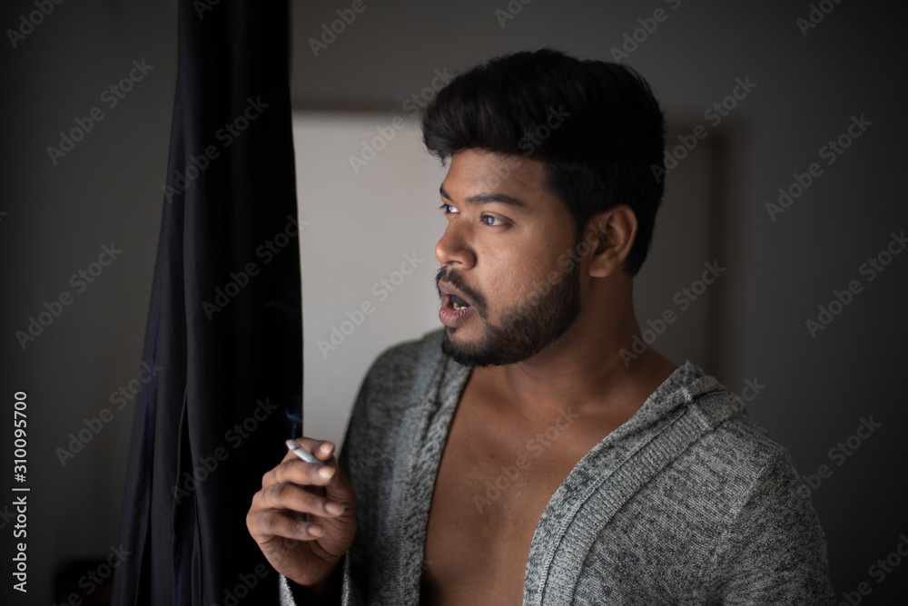 An young tall, dark and handsome Indian Bengali man in a front open ...