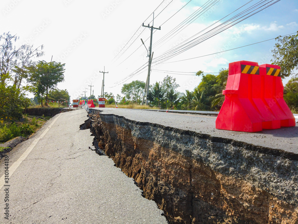 Asphalt road collapsed and fallen. Road collapses with huge cracks ...