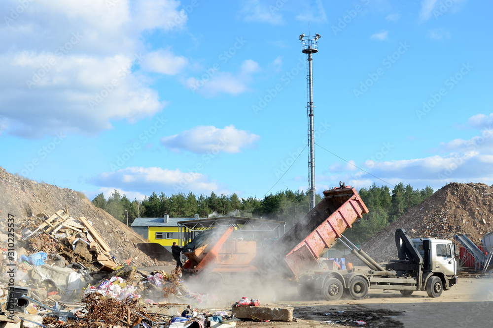 Garbage truck unloads construction waste from container at the landfill ...