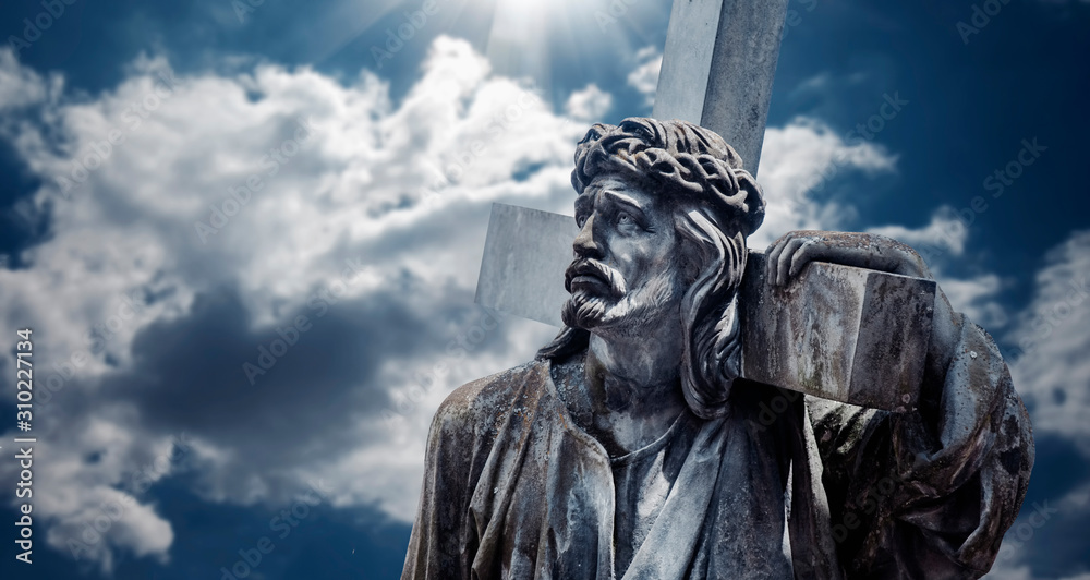 Ancient statue of Jesus Christ with cross. Pain, suffering and ...