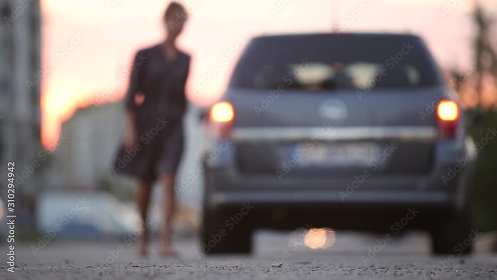 Woman driver putting an emergency stop sign behind broken blurred car ...