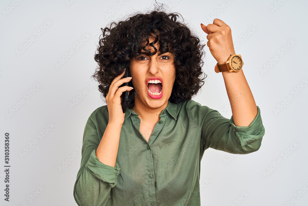 Young arab woman with curly hair talking on smartphone over isolated ...