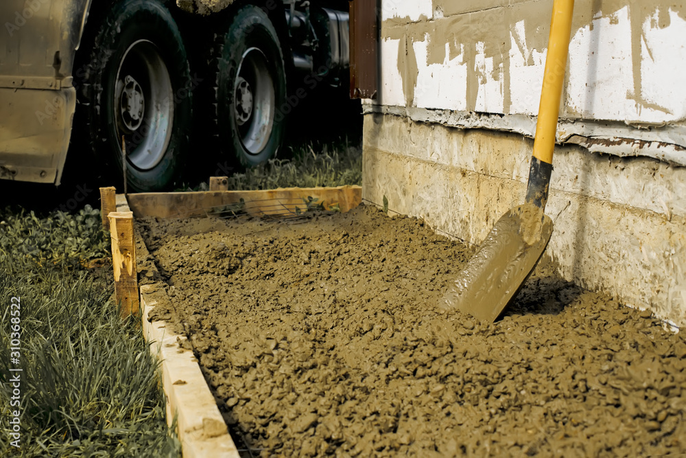 Workmen team in the process of forming foundation blind area. Concrete ...