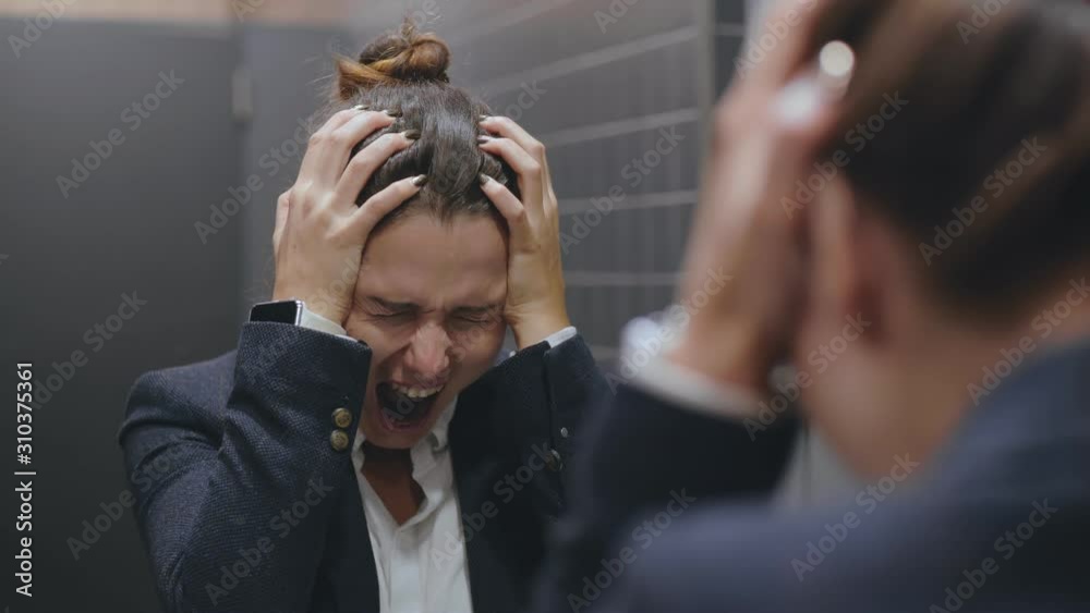 Young caucasian businesswoman sad and desperate creams and shouts in ...
