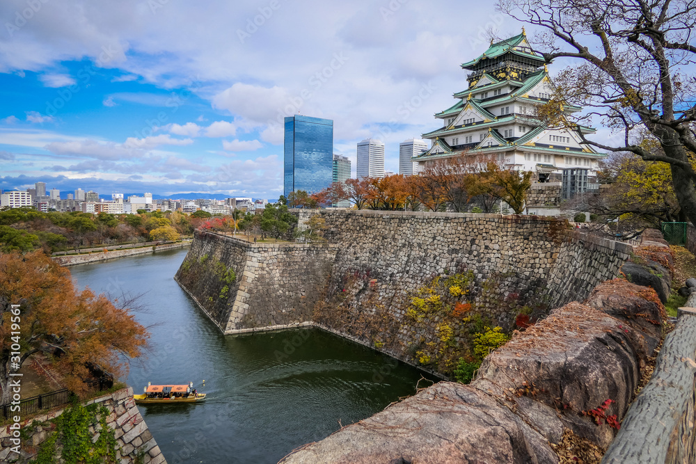Osaka castle surrounded by the stones’ sheer walls with modern building ...