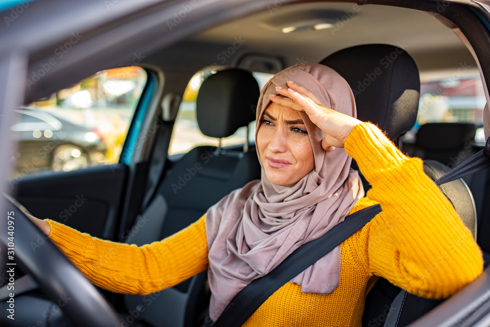 Stressed Muslim woman drive car feeling sad and angry. Distraught mid ...