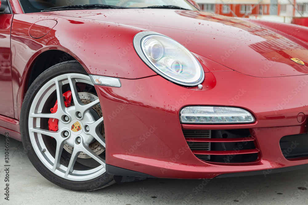 Front headlight and turned wheel view of car Porsche 911 Carrera 4s ...