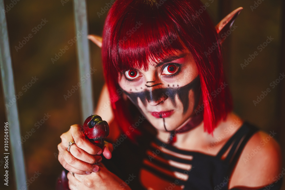 Girl cosplay in the image of a dark elf in a red wig portrait close-up ...