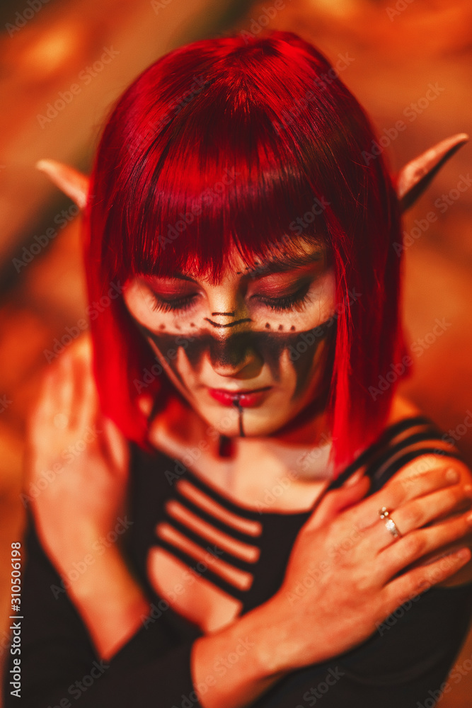 Girl cosplay in the image of a dark elf in a red wig portrait close-up ...