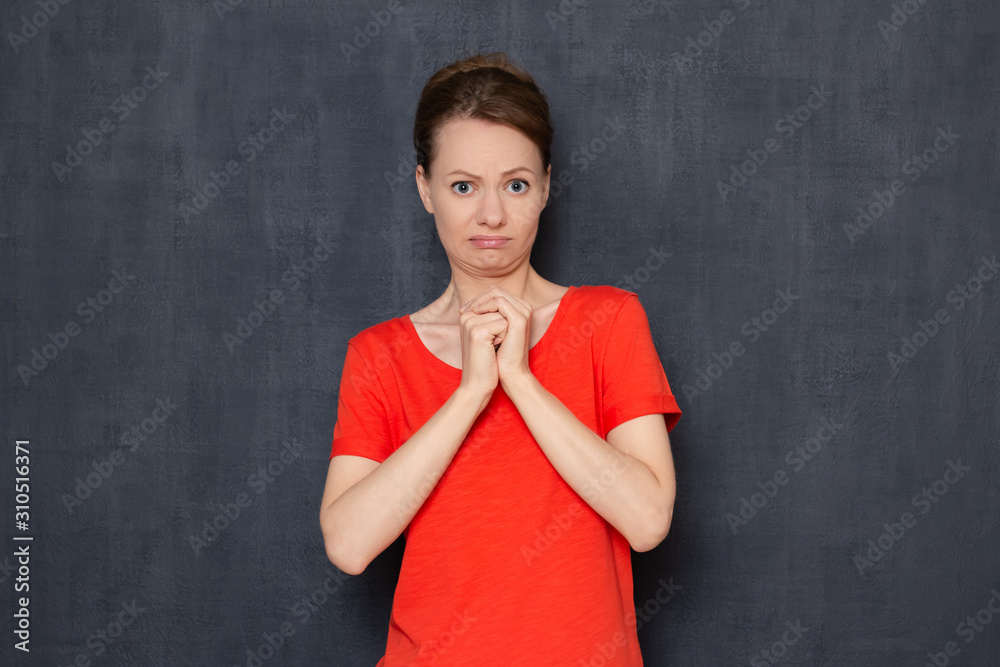 Portrait of scared bewildered girl holding clasped hands on chest Stock ...