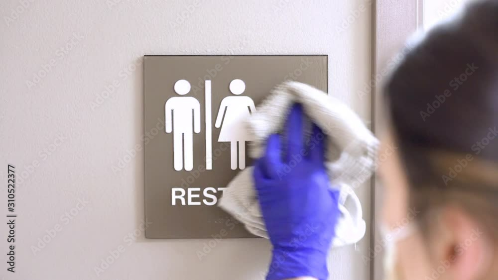 Slider movement of janitor woman cleaning male female restroom sign on ...