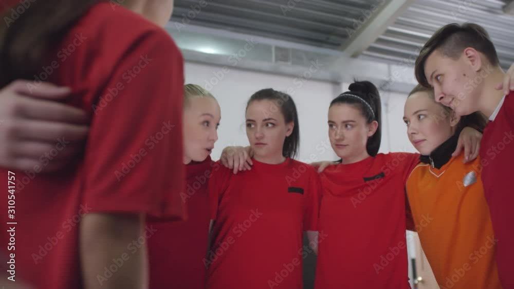Team of young female soccer athletes in sports uniform standing in ...