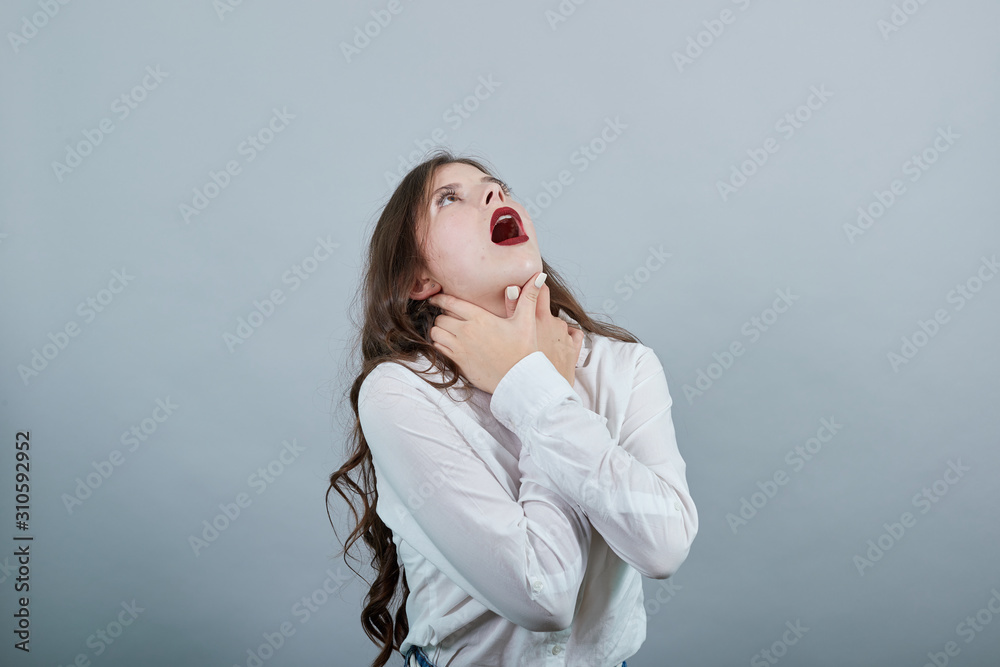 Attractive young woman in fashion white shirt holding hands on neck ...