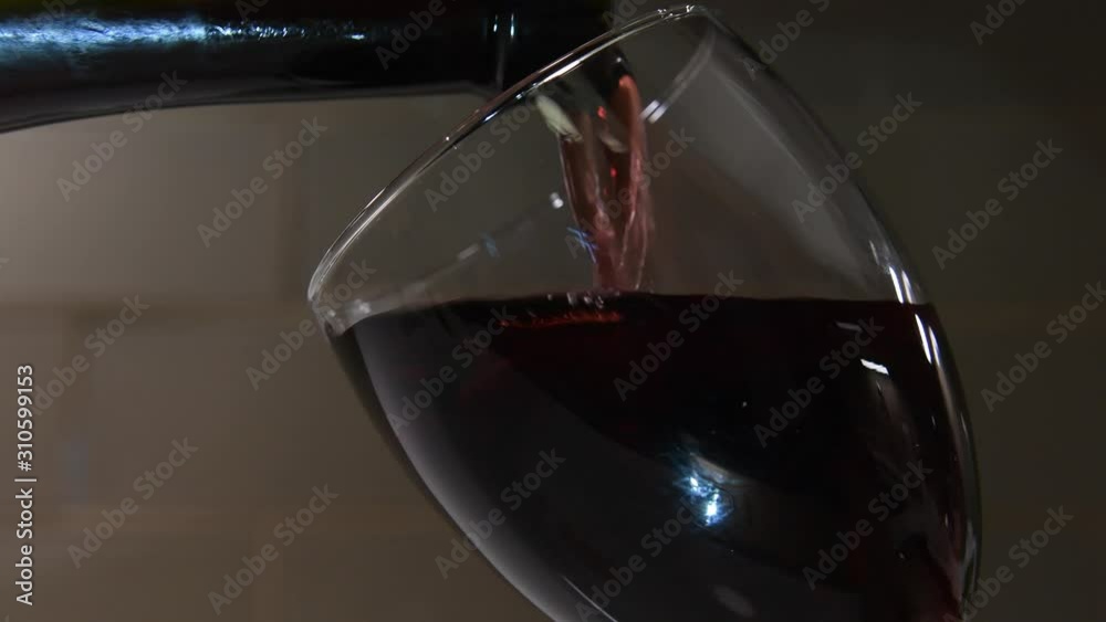 Video close up of glass of wine and pouring red wine into glass. Pinot ...