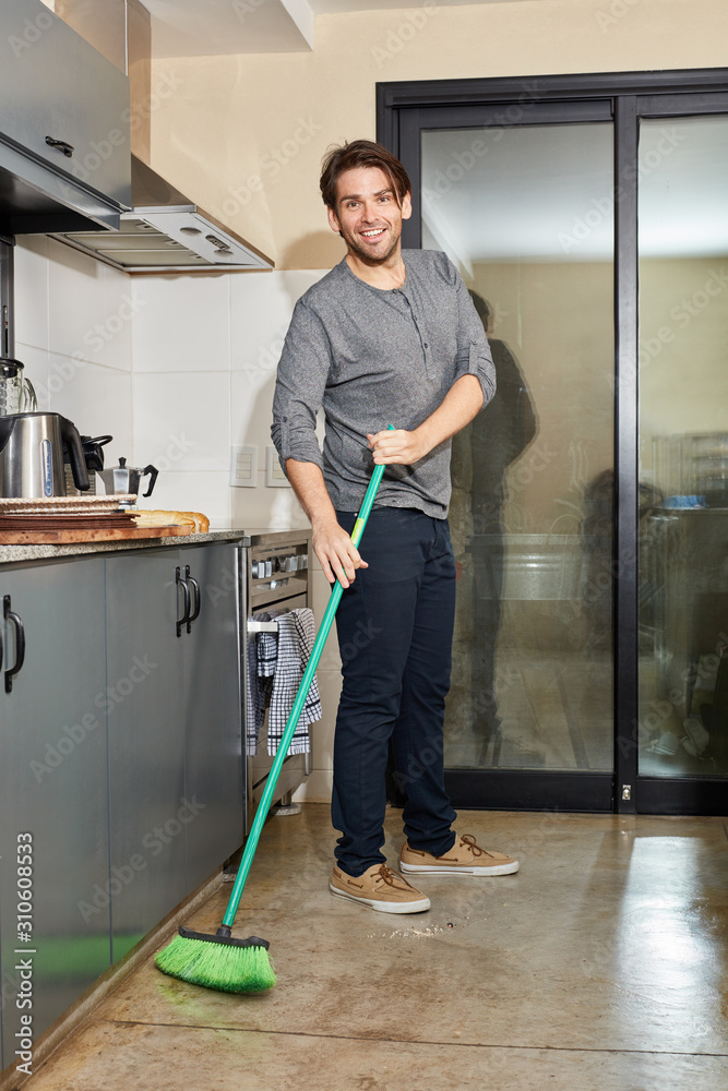 Man as a houseman during spring cleaning in the kitchen Stock Photo ...