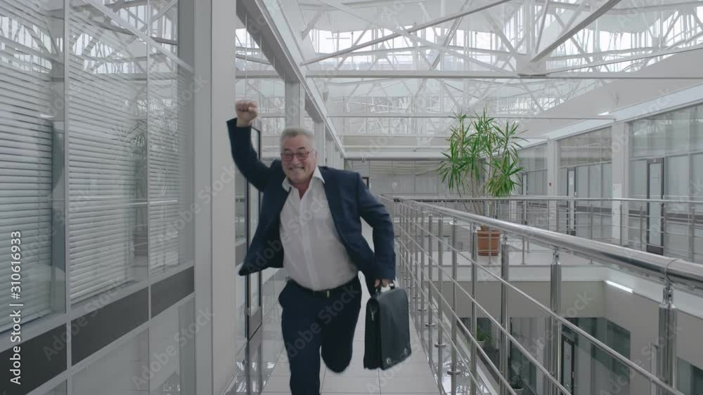 Businessman in formal suit running through office hall atrium of ...