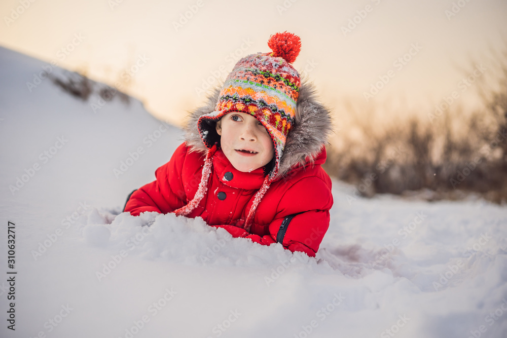 Boy in red fashion clothes playing outdoors. Active leisure with ...